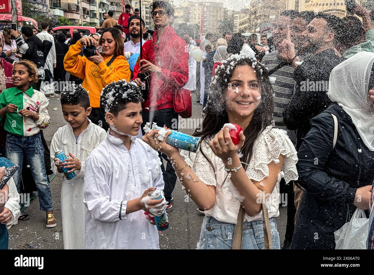 Cairo, Egypt. 10th Apr, 2024. Children playfully spray foams to celebrate Eid al-Fitr that marks ...