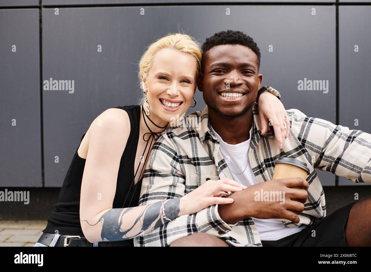 A happy, multicultural couple - boyfriend and girlfriend - sitting next ...