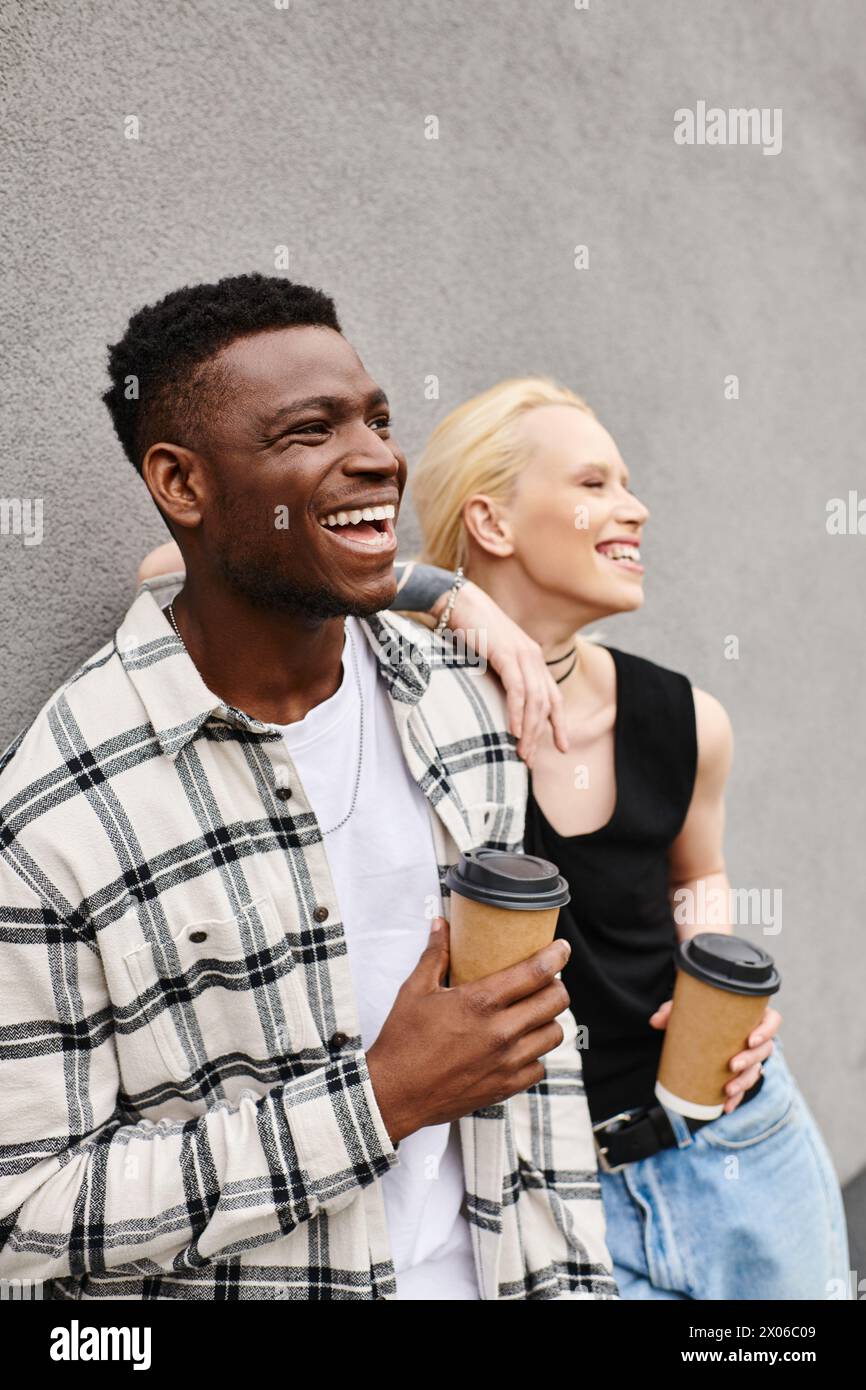 Multicultural couple enjoying coffee together on an urban street near a ...