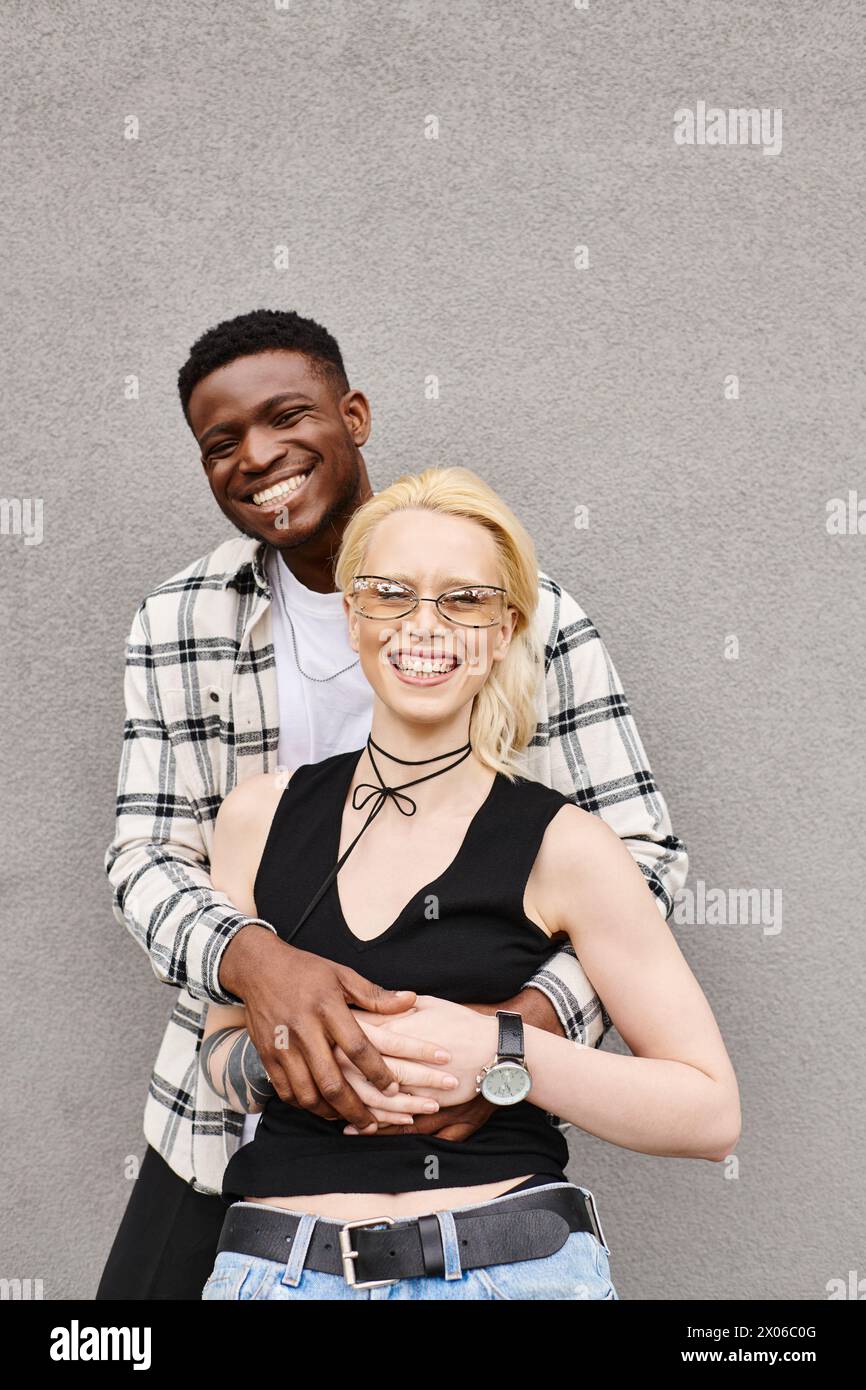 A multicultural man and woman stand together on an urban street ...
