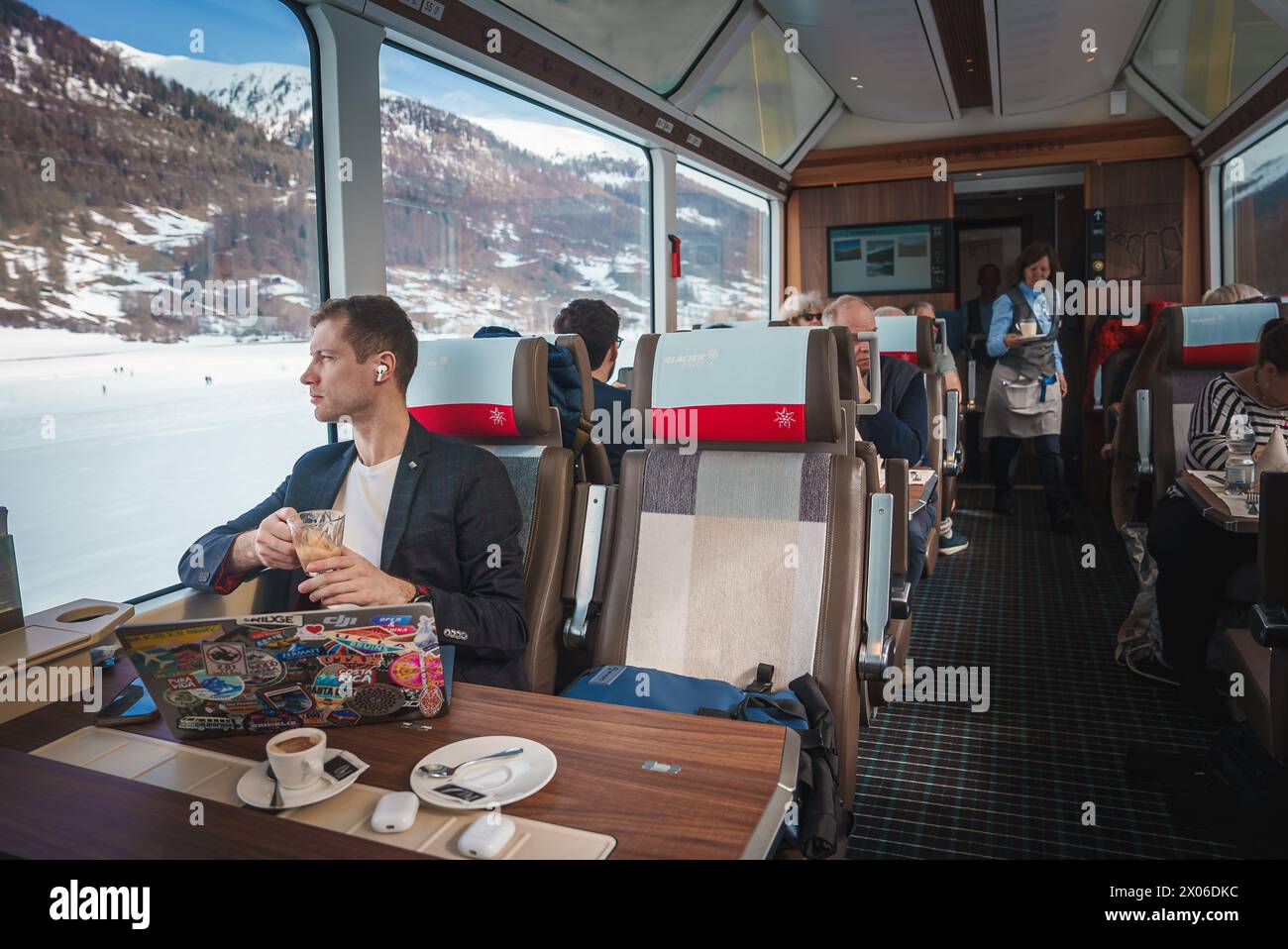 Alpine train interior with young man looking out window on Glacier ...