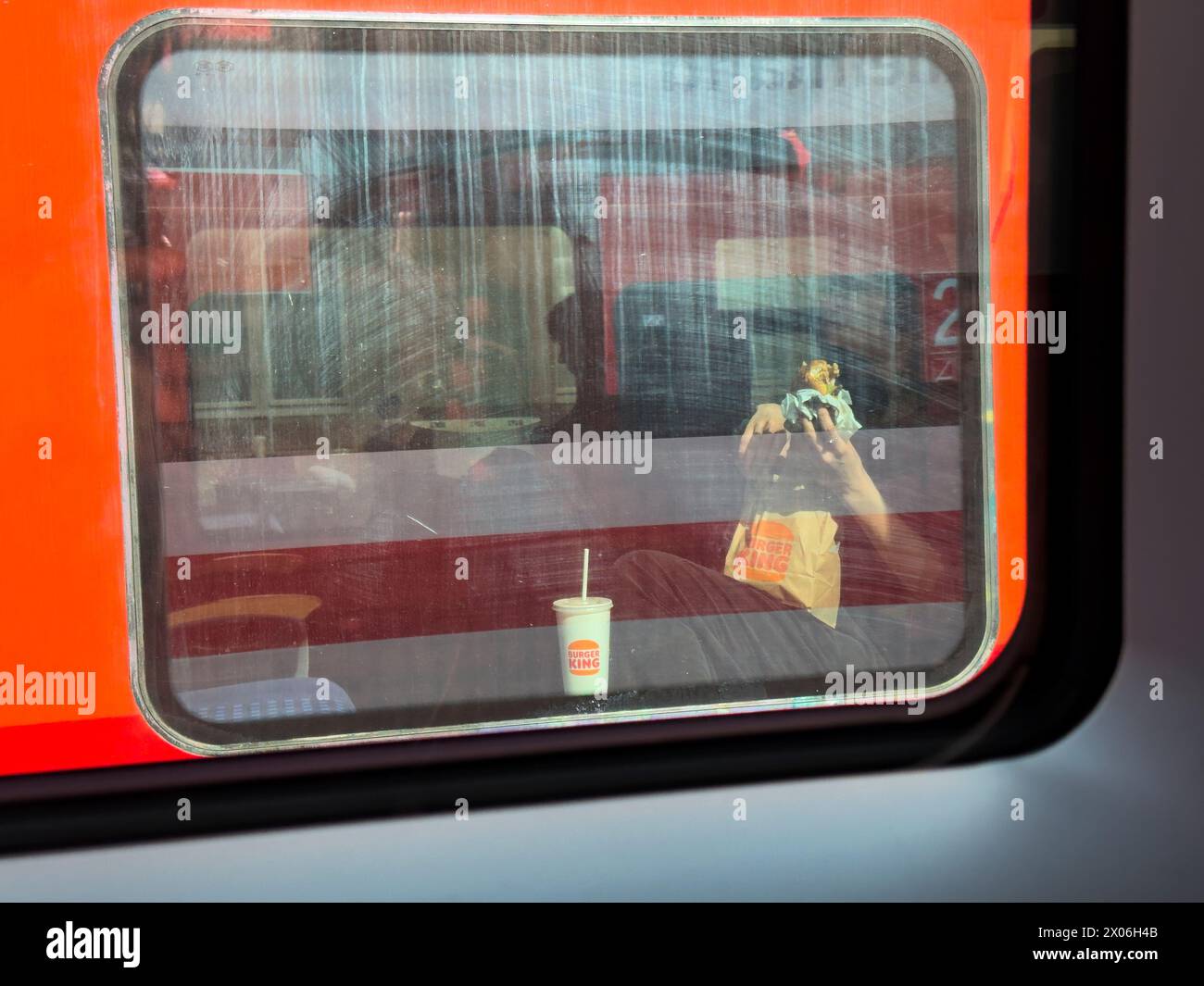 A female traveller eats fast food of Burger King in the train at ...