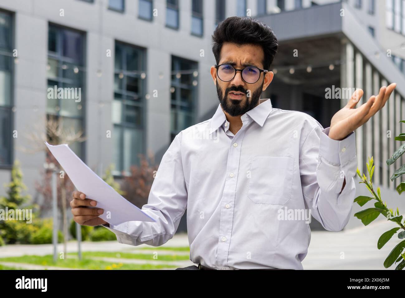 Portrait of an upset and disappointed young Indian man sitting outside ...