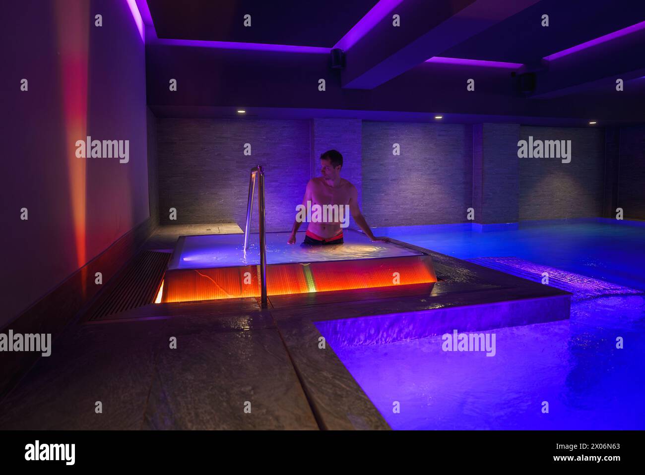 Luxury hotel pool area illuminated with vibrant LED lights in Zermatt ...