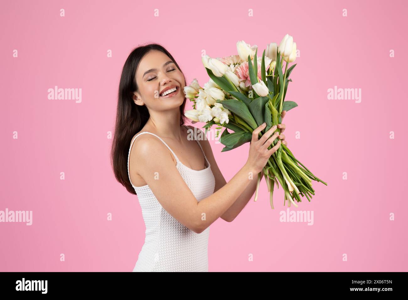 Beautiful lady laughing with flowers in hand Stock Photo - Alamy