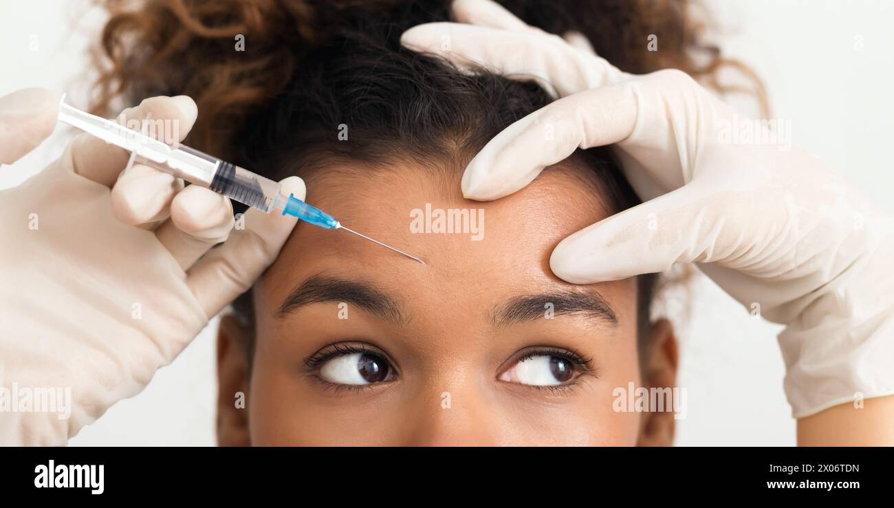 African-american woman getting botox injection in forehead Stock Photo ...