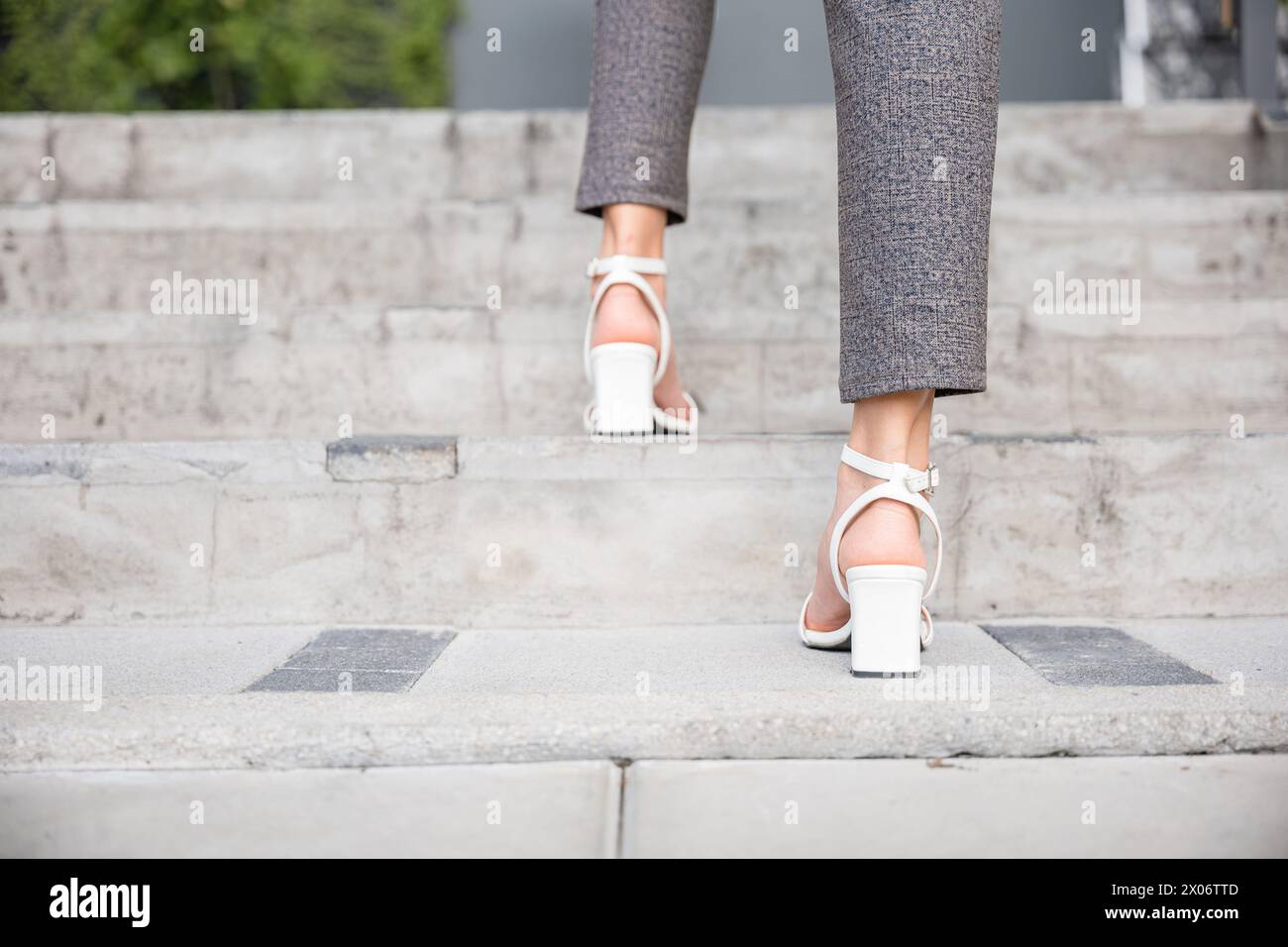 An abstract portrayal of a businesswoman black shoe stepping up city ...