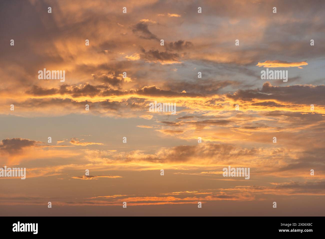 The sky at dusk is enveloped in a tapestry of gold and amber, with ...