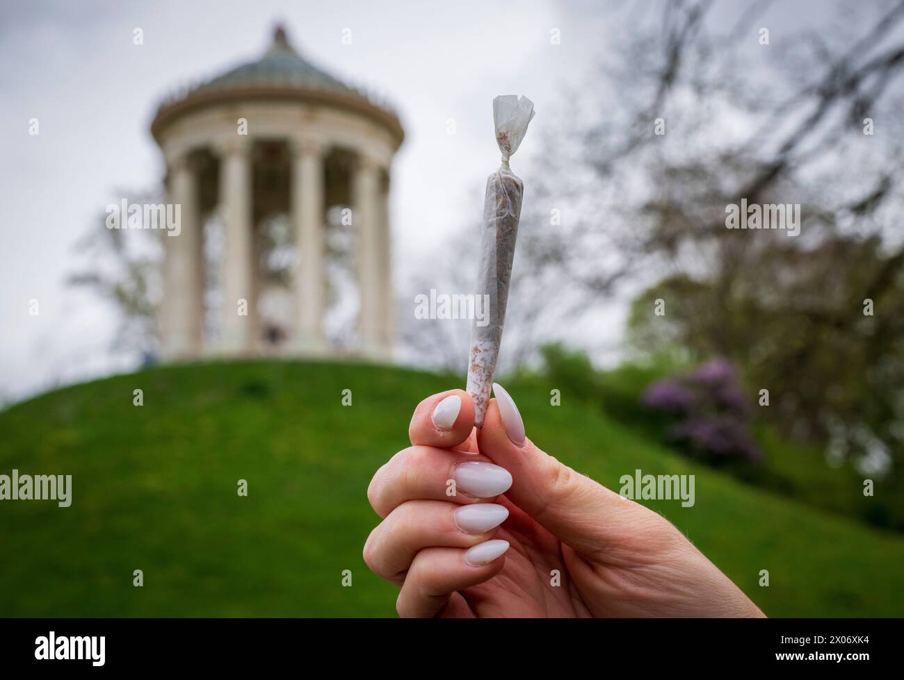 Munich, Germany. 10th Apr, 2024. A woman holds a joint against the ...