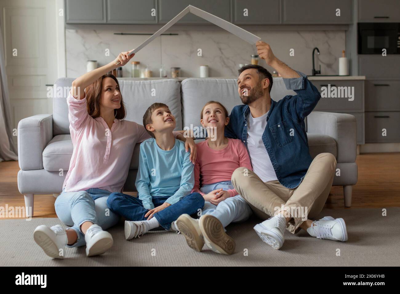 Family creating house shape with carton card Stock Photo - Alamy