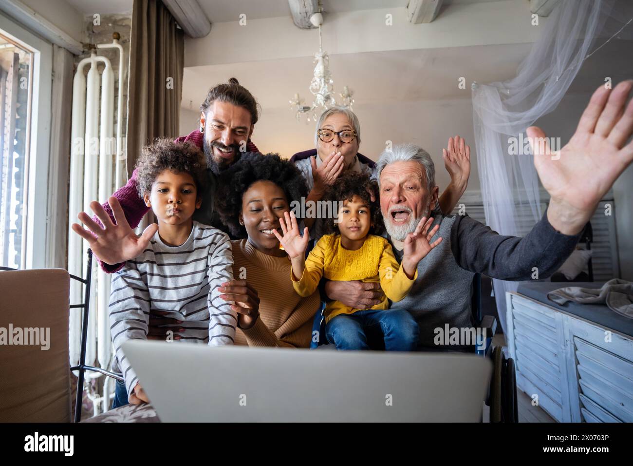 Happy multi-generation diverse family gathering around notebook and ...