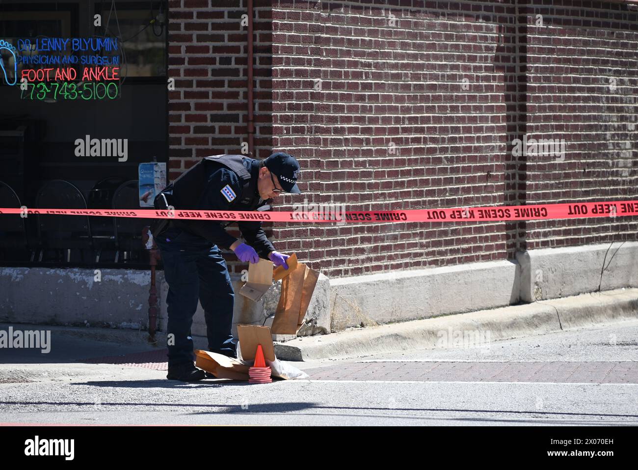 A Police officer from the Chicago Police Department collects evidence ...