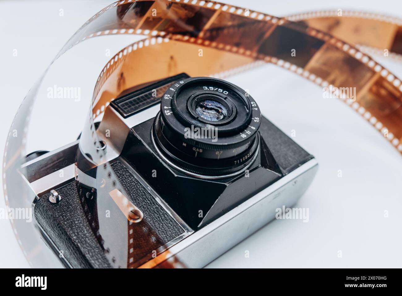 An artistic display of a vintage camera intertwined with a curling film ...