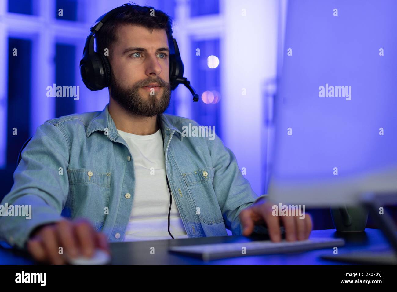 Focused gamer with computer at night in neon light Stock Photo - Alamy