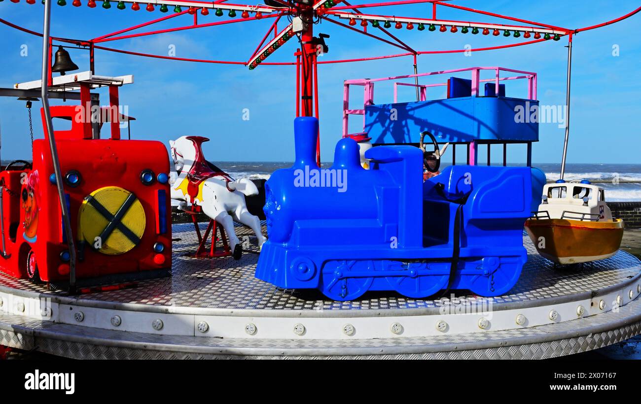 Children`s fair ground ride on Tywyn promenade, Gwynedd Wales with ...