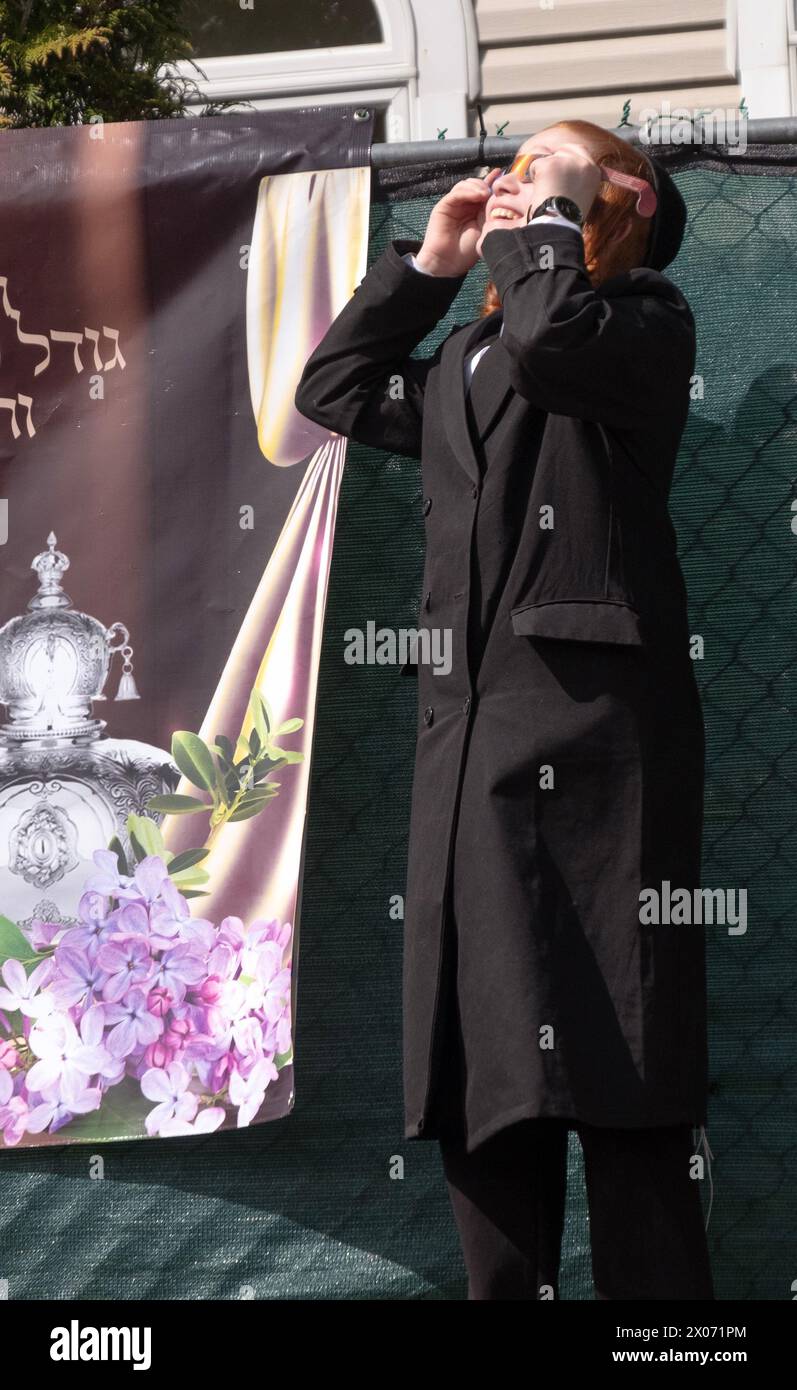 An orthodox Jewish student checks out the 2024 solar eclipse in MOnsey ...