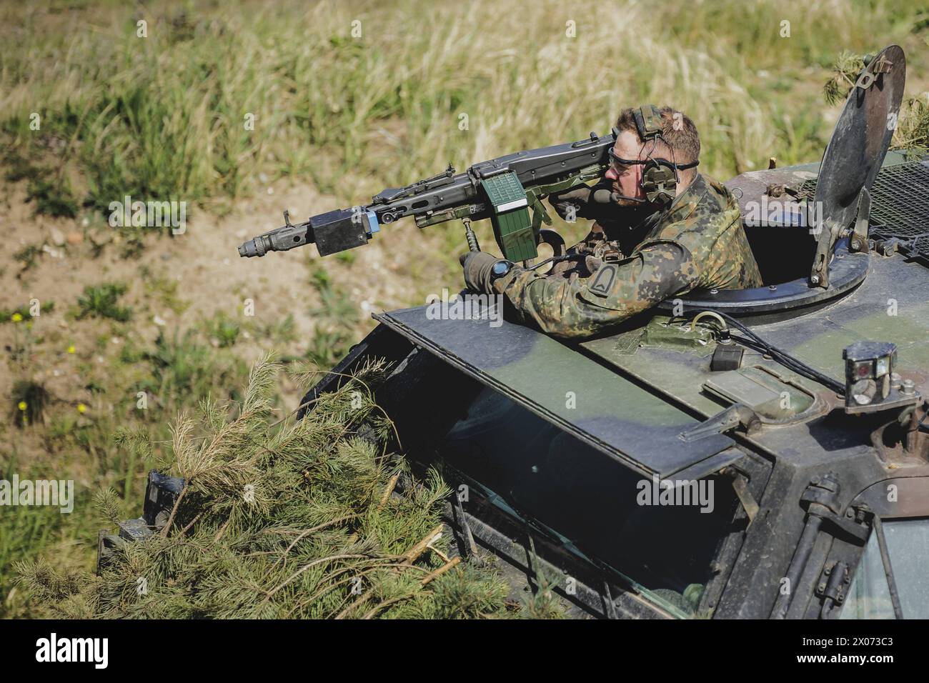 Ein Soldat bedient ein Maschinengewehr auf einem gepanzerten Fahrzeug ...