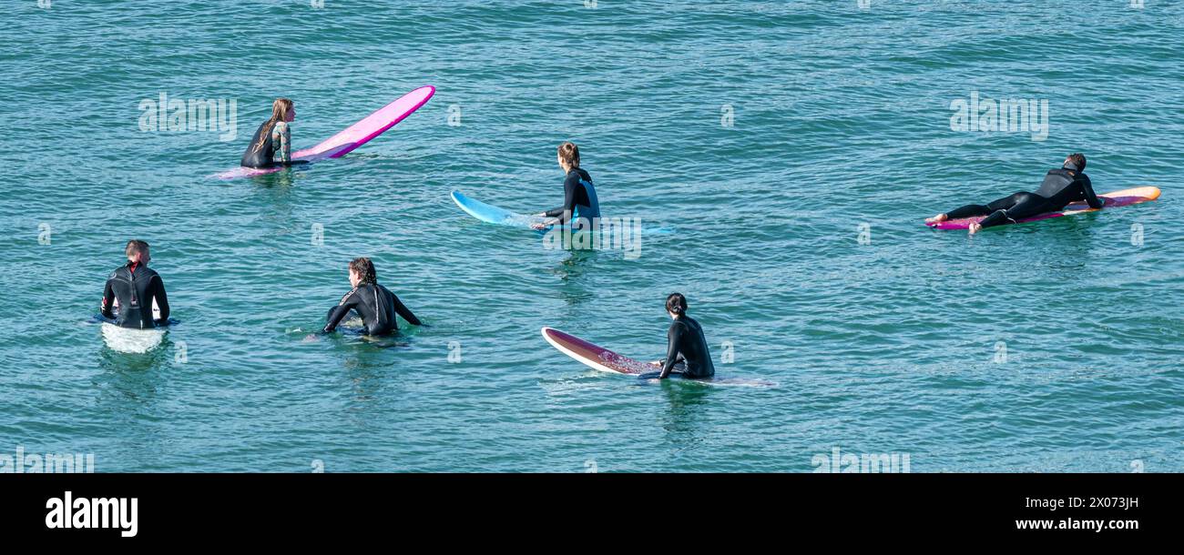 A panoramic image of surfers and their surfboards floating in the sea ...