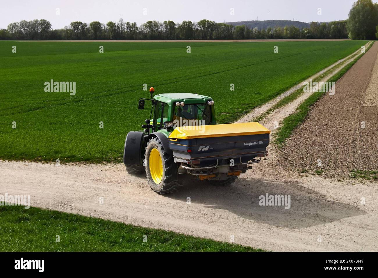 Landwirtschaft, John Deere Traktor auf einem Feld. Saat bzw Saatgut ...
