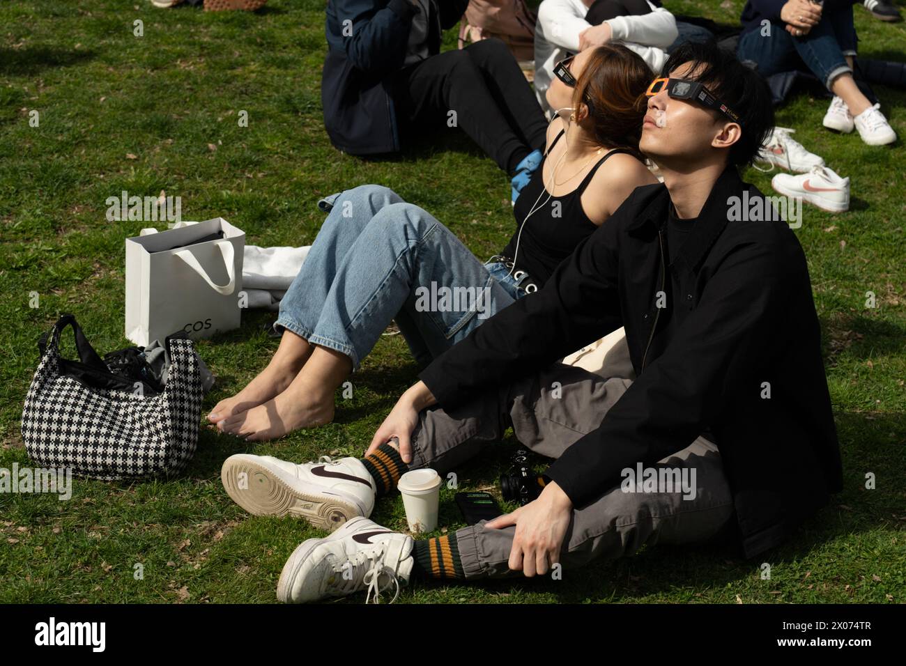 A couple watches the 2024 Solar Eclipse together, sitting on the the ...