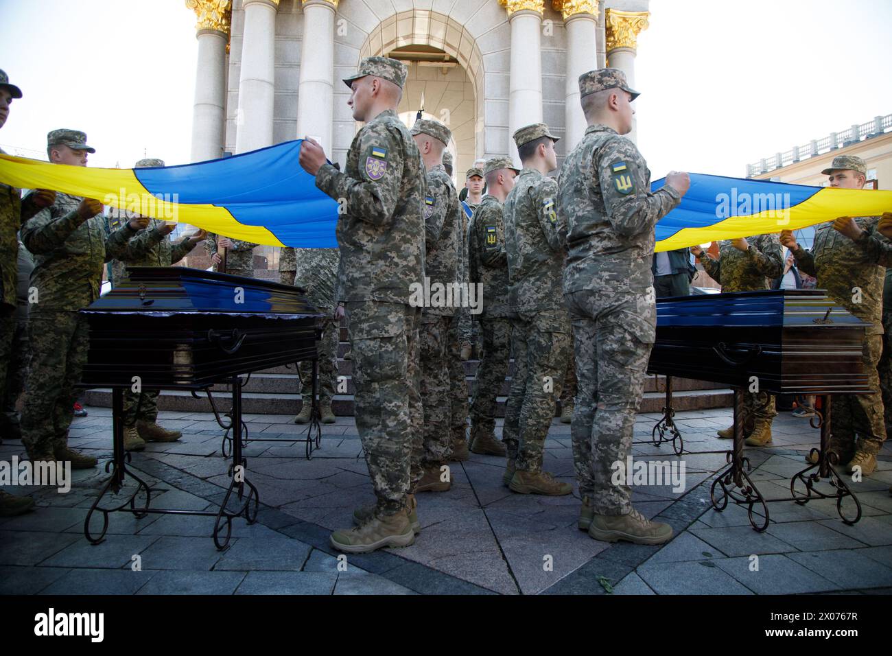 KYIV, UKRAINE - APRIL 9, 2024 - Servicemen hold Ukrainian flags over ...