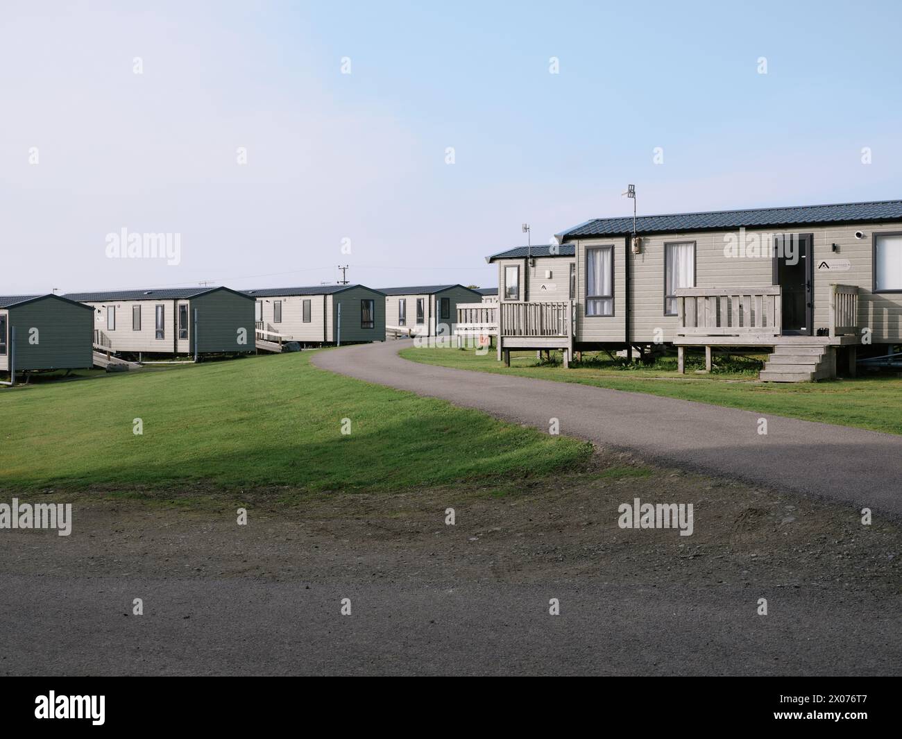 A typical mobile home, static caravan holiday park with grass and sky ...