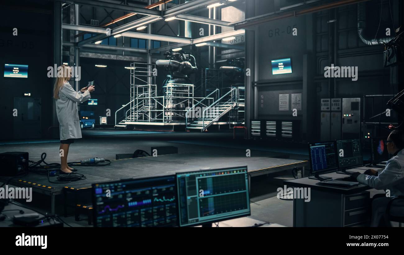 Female Engineer Uses Tablet Computer while Working in an Industial ...