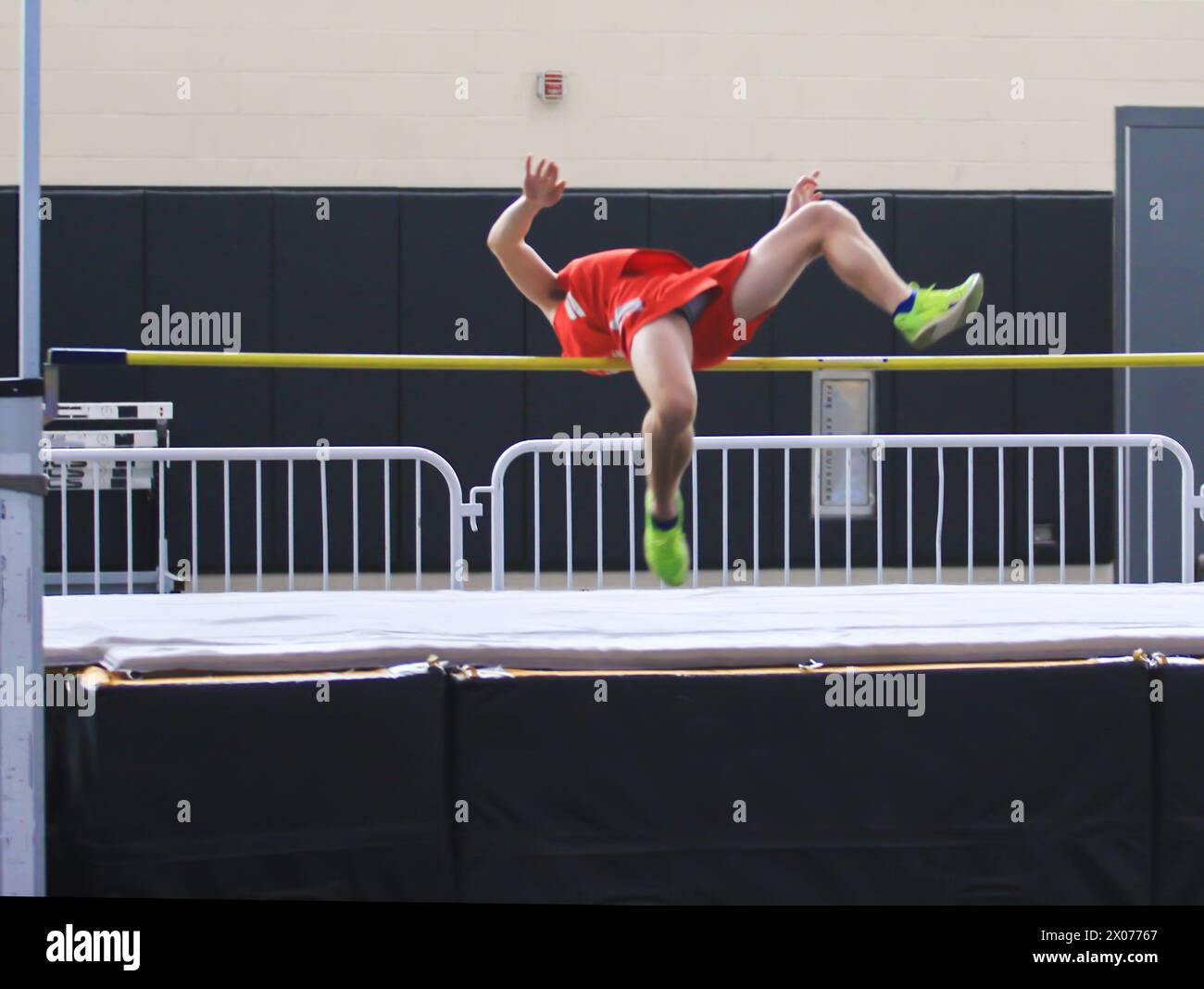 One high school boy going over the bar in the high jump during an ...