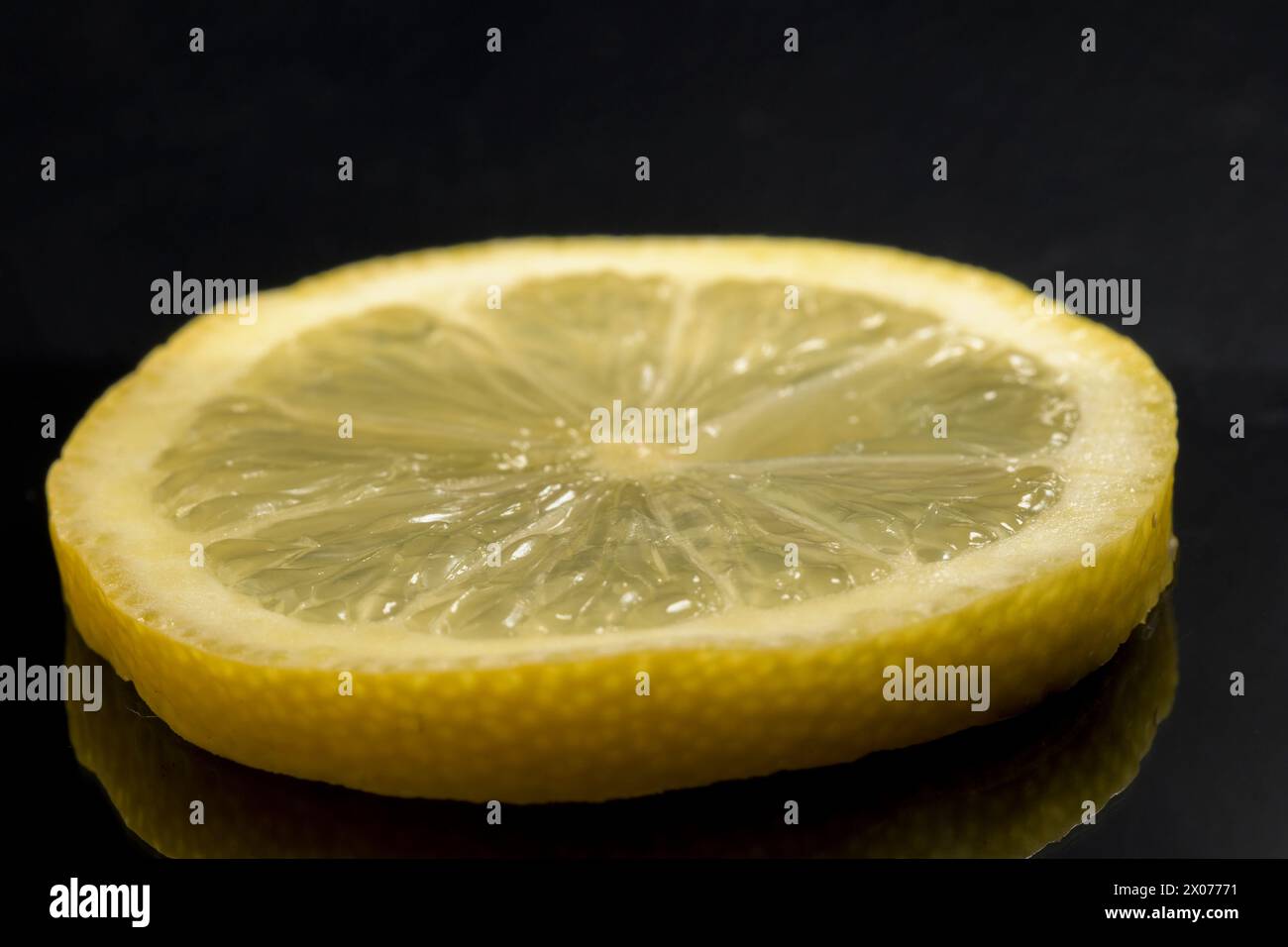 Macro detail of fresh yellow lemon slice split with black background ...