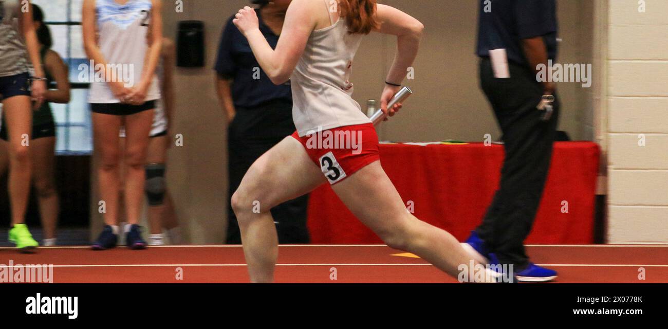 Side view of a female runner running fast on an indoor track Stock ...