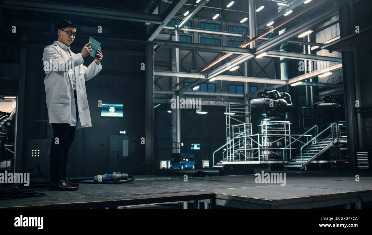 Male Engineer Uses Tablet Computer while Working in an Industial ...