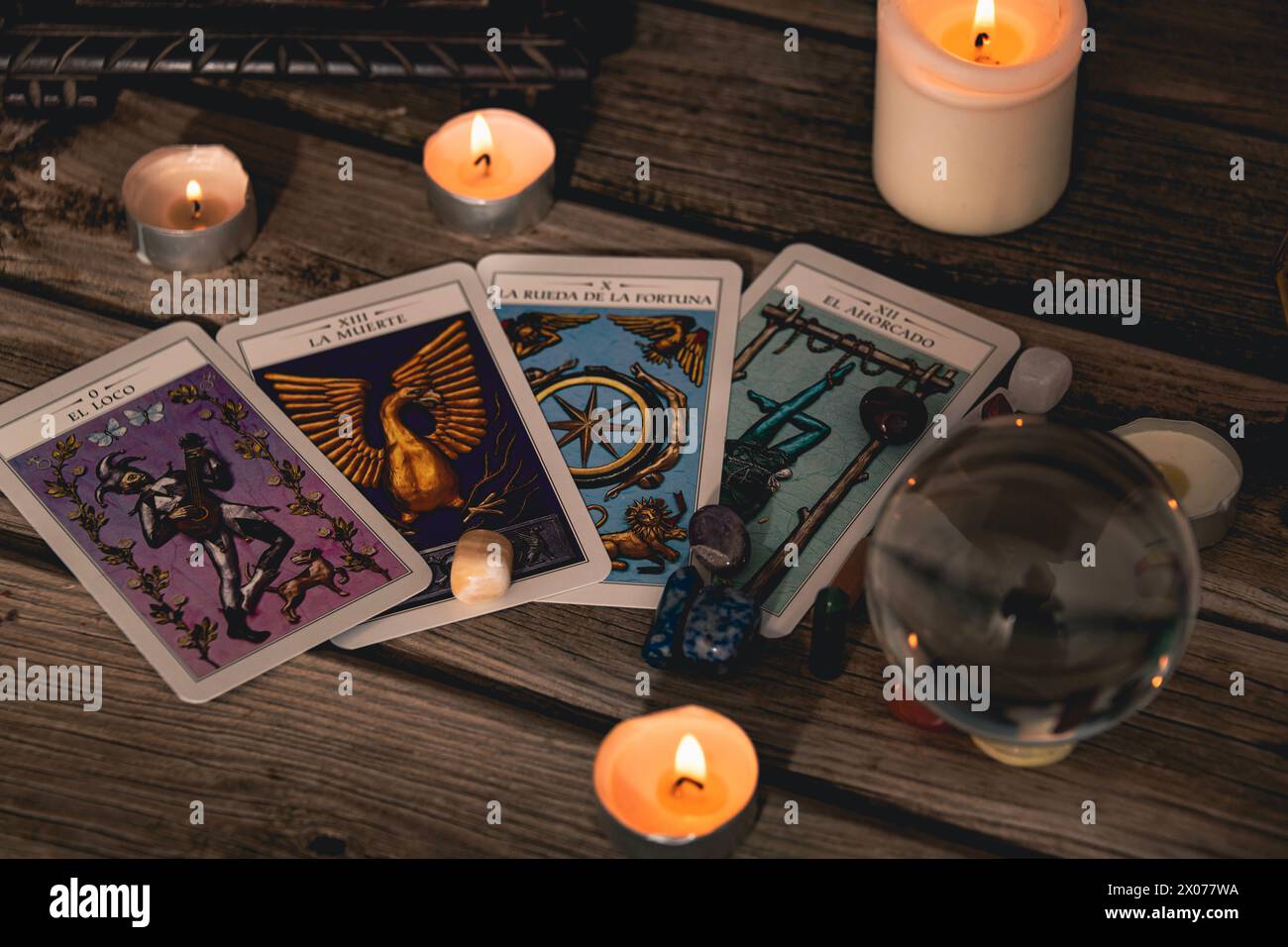 Close-up of a tarot card arrangement with a crystal ball and flickering ...