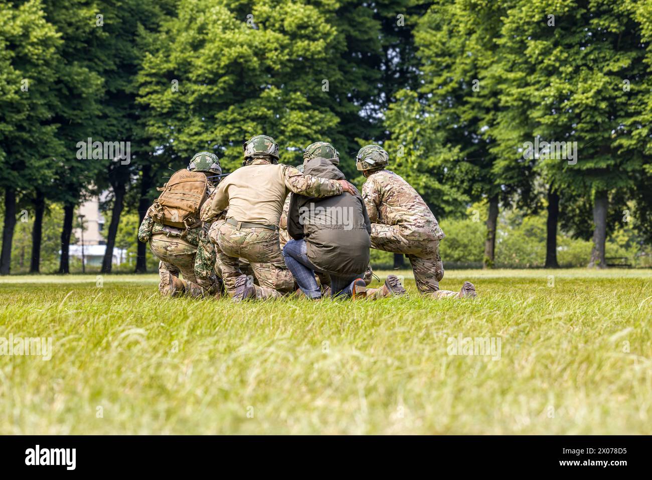 Soldiers and a civilian are waiting to be picked up by a helicopter ...