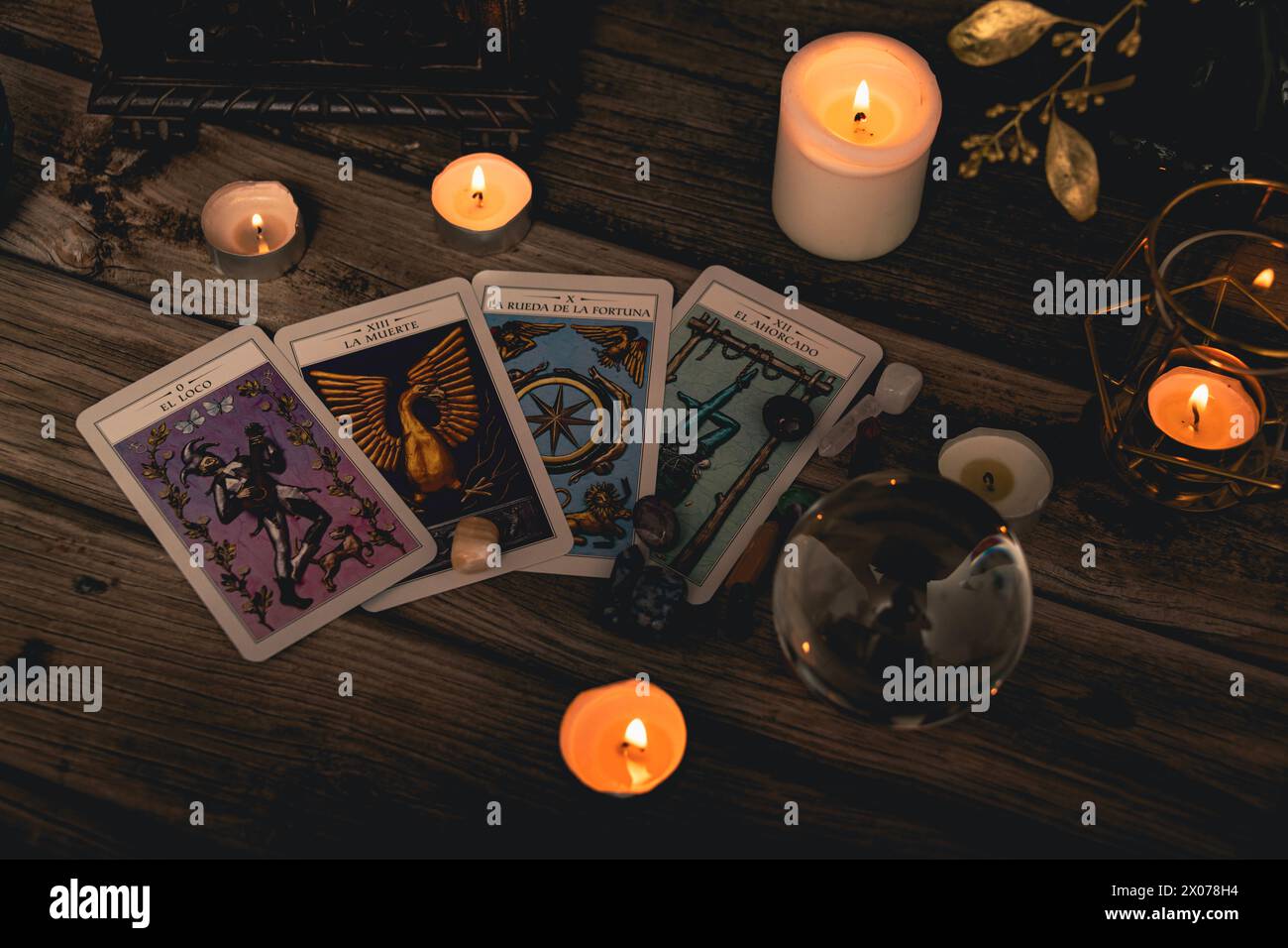 Close-up of a tarot card arrangement with a crystal ball and flickering ...