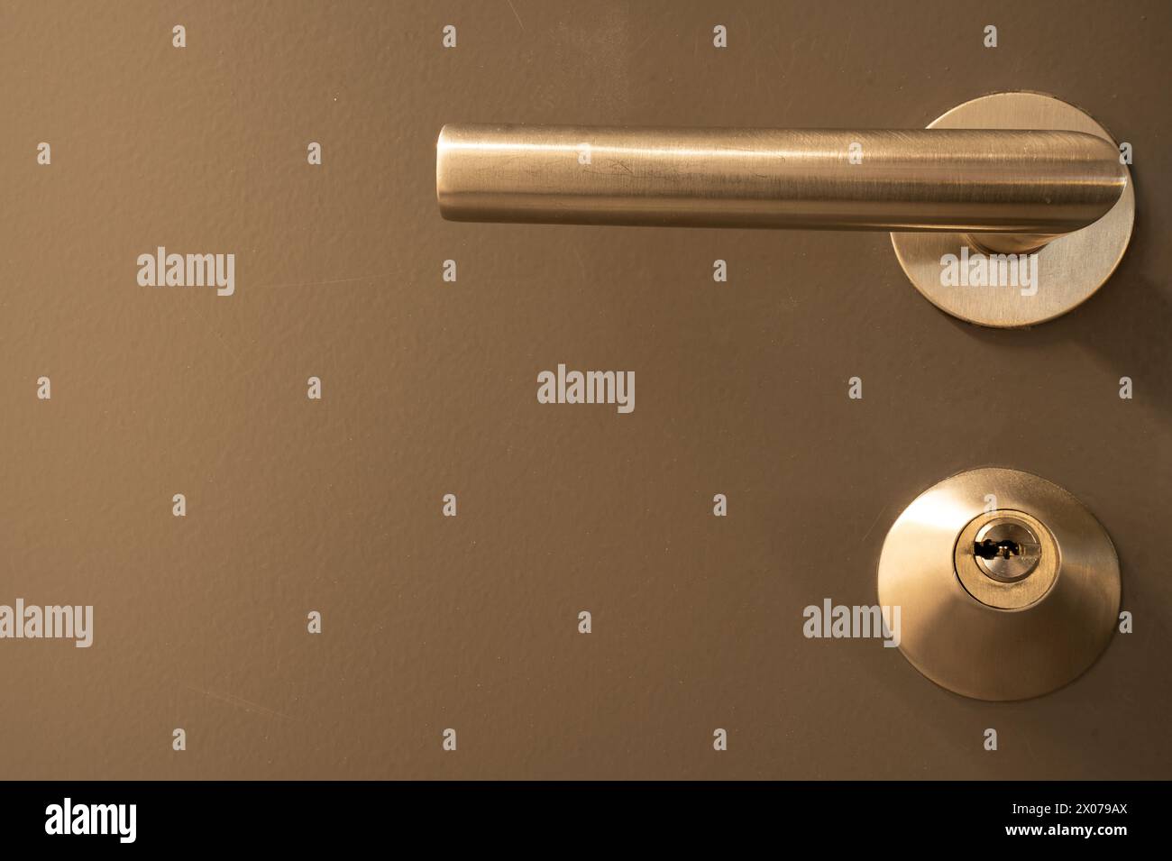 Door handle and lock of entrance door of an apartment. Door has dark ...