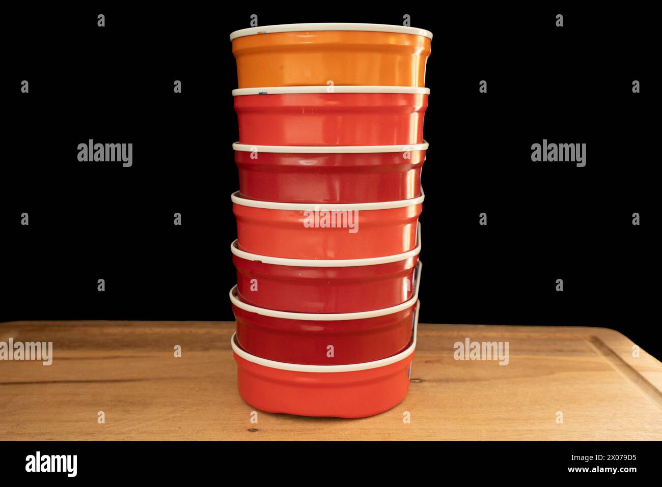 Stacked fish cans on a coaster in different reddish colors, from orange ...