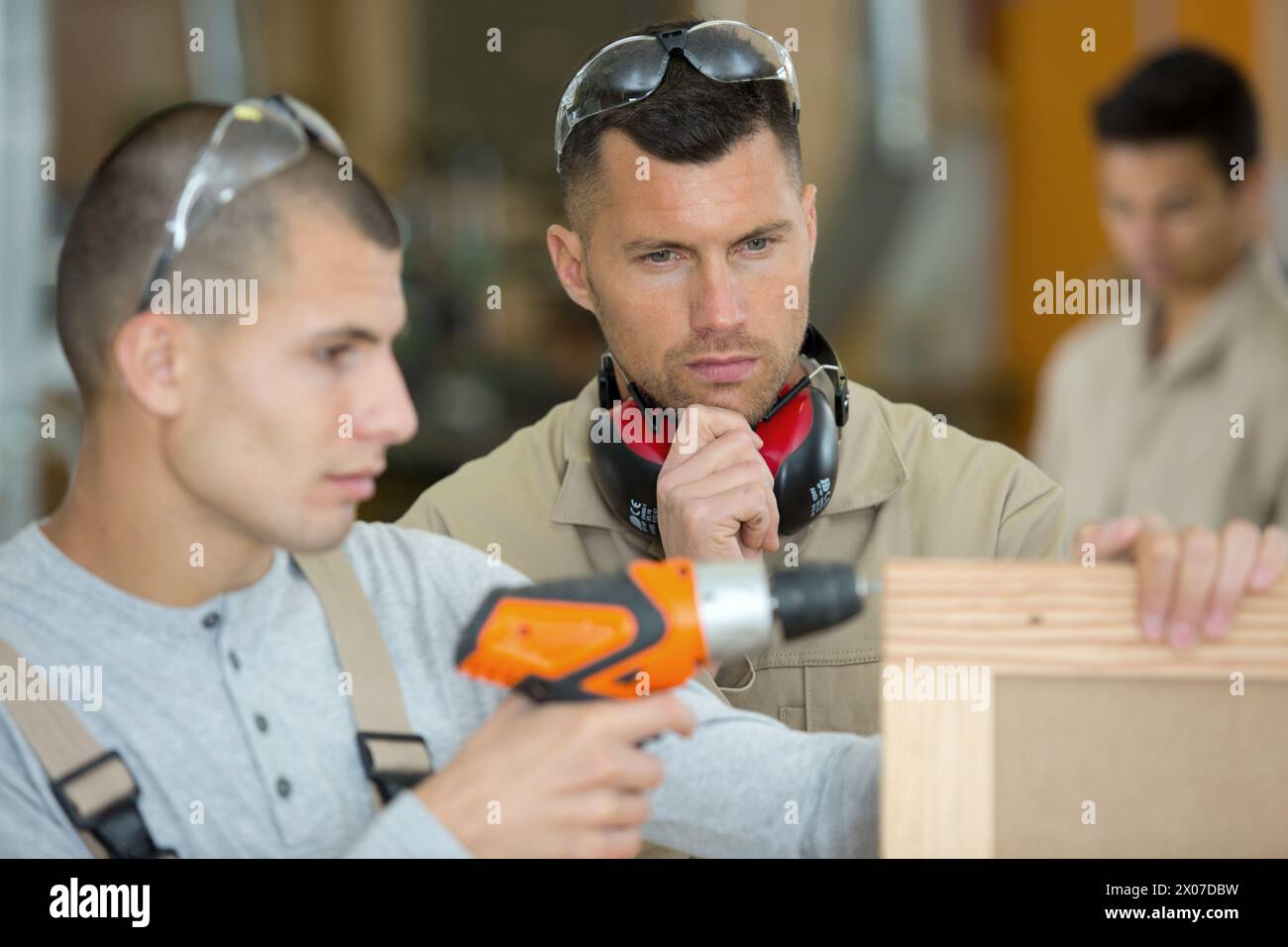 apprentice learning to use a driller Stock Photo - Alamy