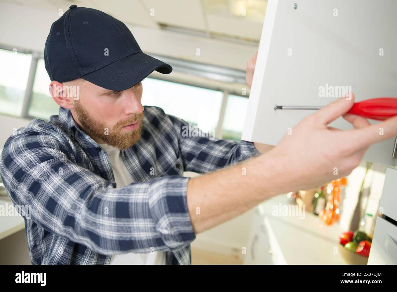 a worker installing cabinet doors Stock Photo - Alamy