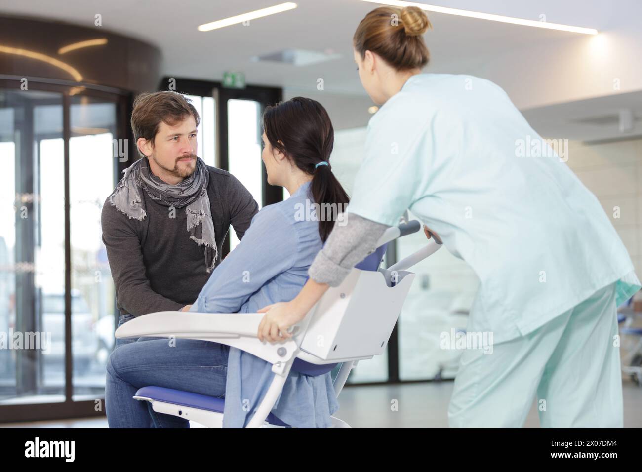 obstetrician doctor pushing pregnant woman in wheelchair Stock Photo ...
