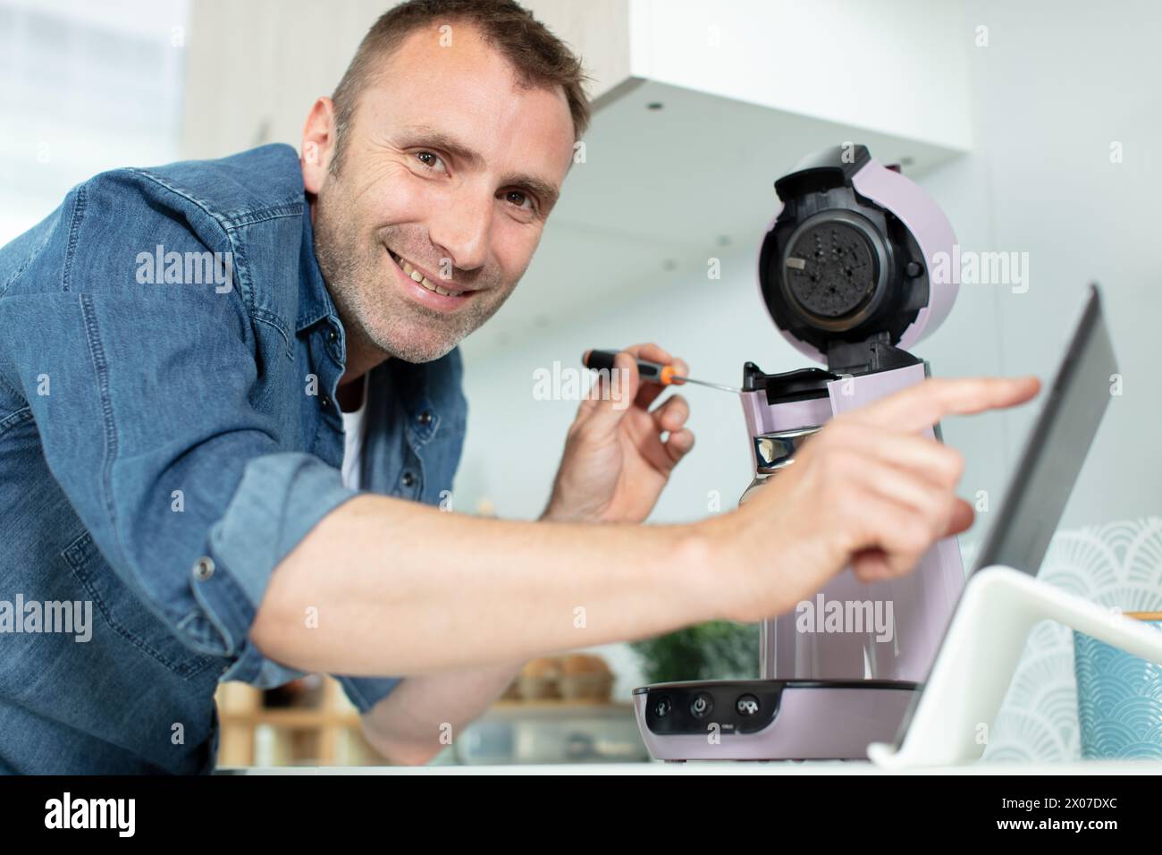 serious man repairing broken coffee machine Stock Photo - Alamy
