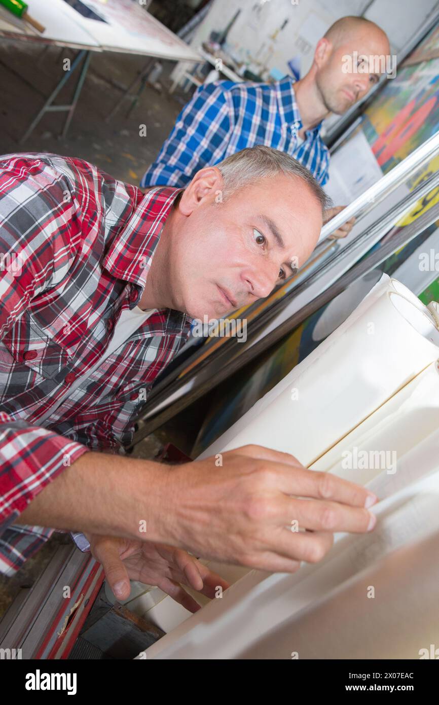 advertising agency sticking the ads on the glass window Stock Photo - Alamy
