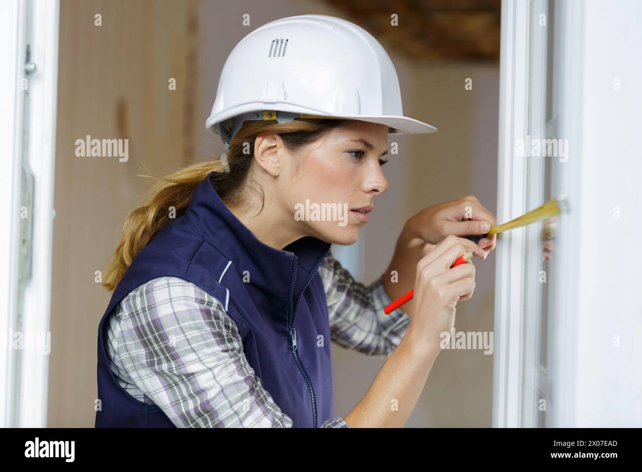 portrait of a woman builder measuring window Stock Photo - Alamy