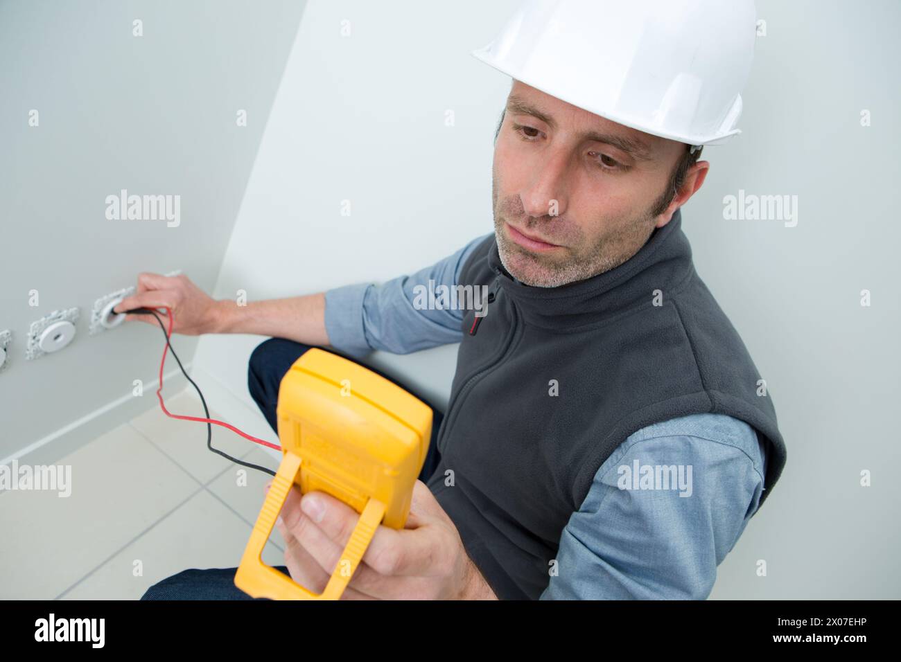 service man installing power socket in wall Stock Photo - Alamy