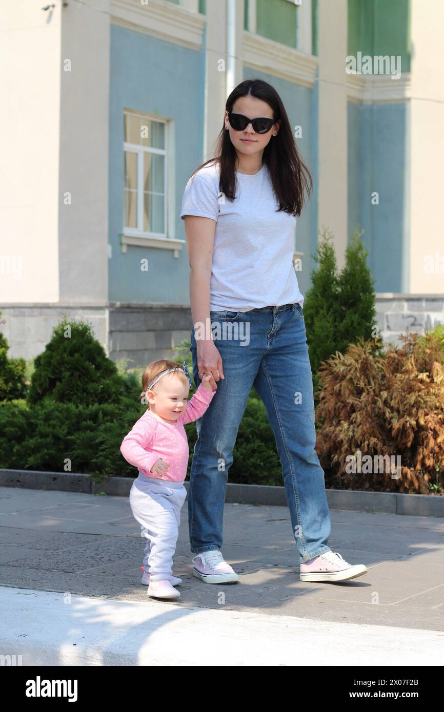 Mom and child walk hand in hand Stock Photo - Alamy