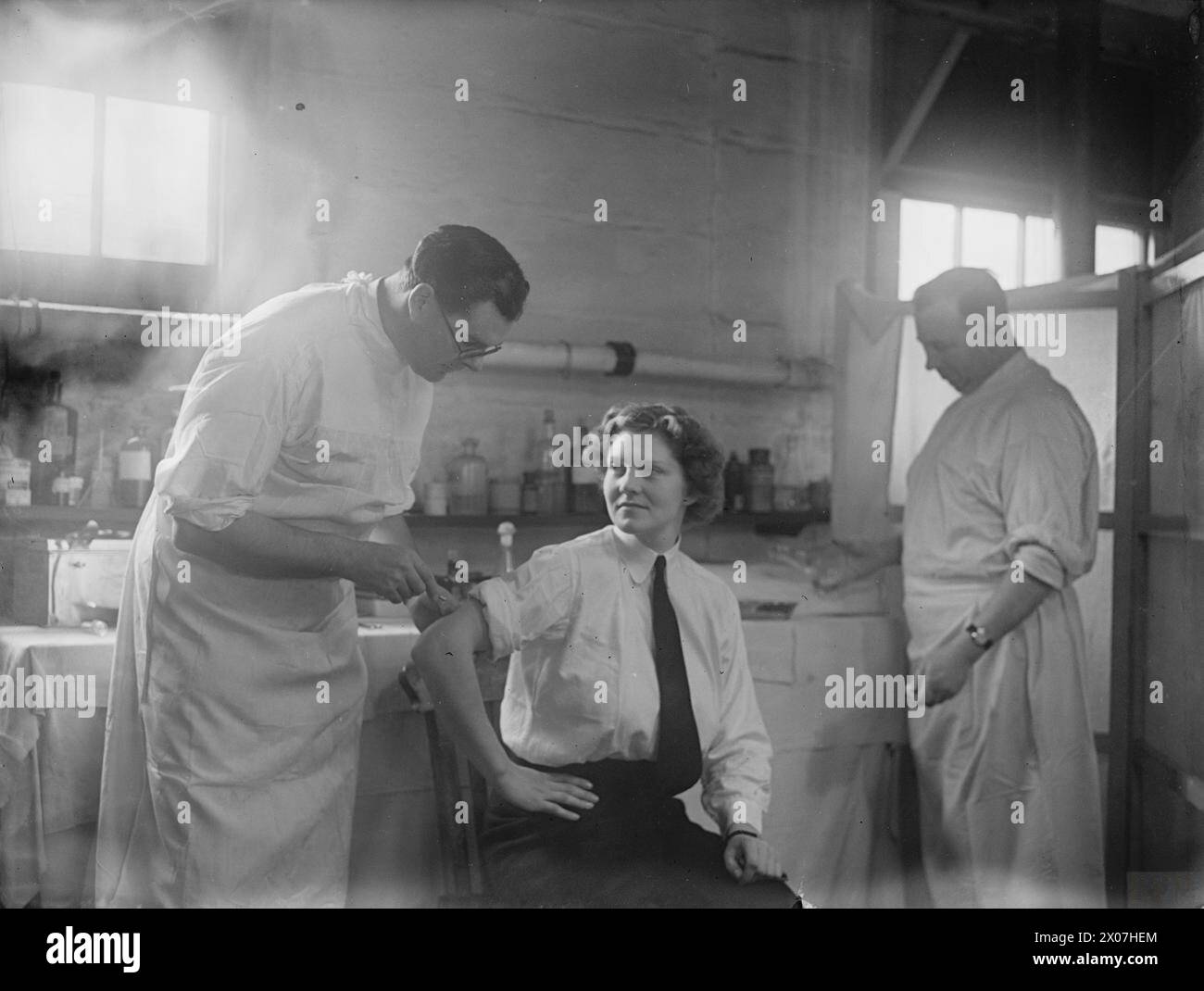 In 1940, WRNS personnel at a Royal Navy barracks receive inoculations ...