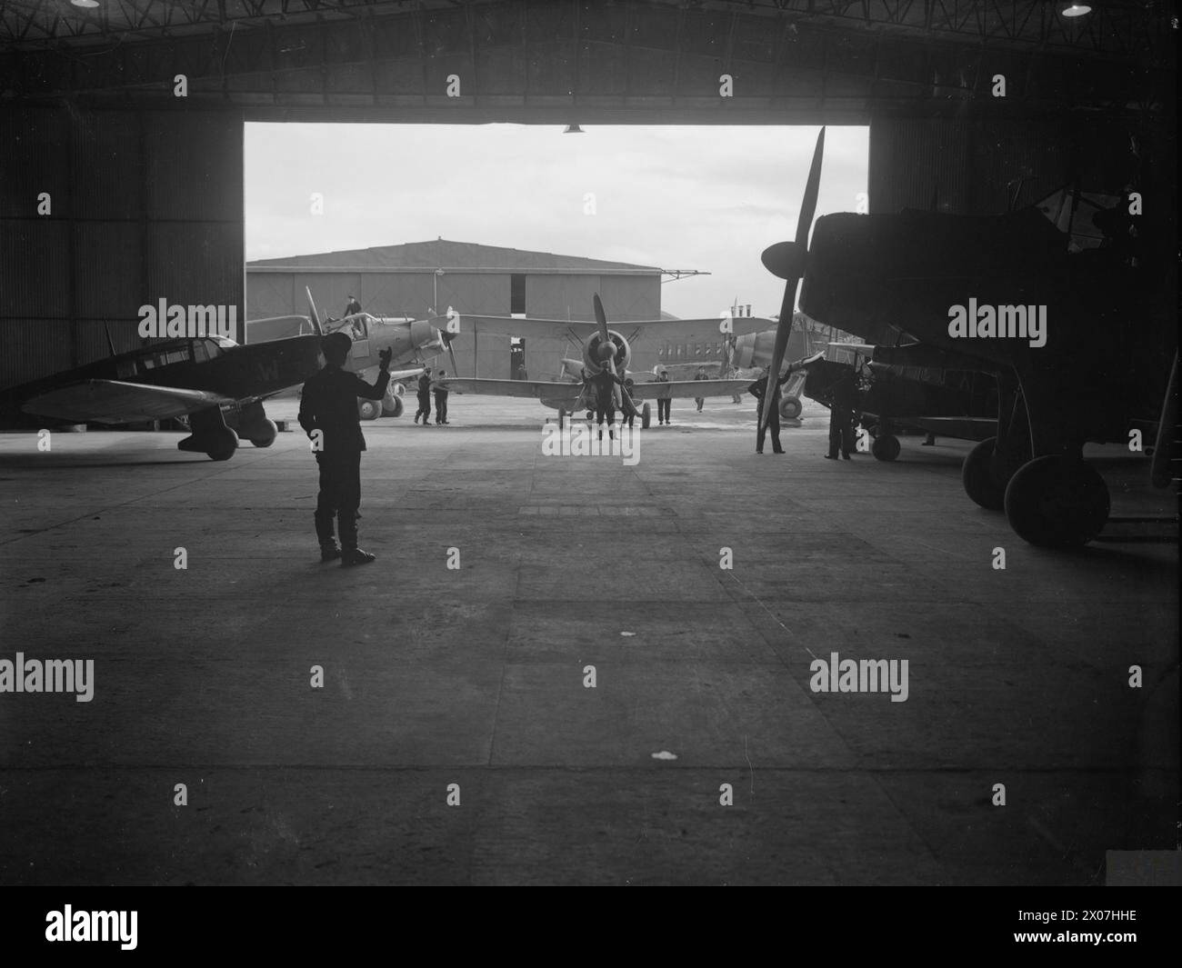 A Fairey Swordfish aircraft is moved into its hangar at HMS Sparrowhawk ...