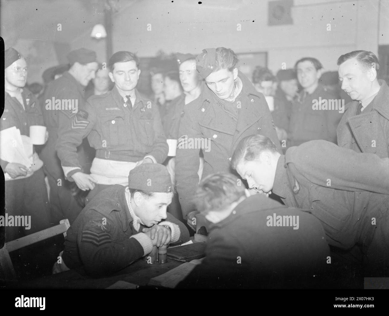 Air crews returning from Berlin in 1944 are shown being interrogated ...