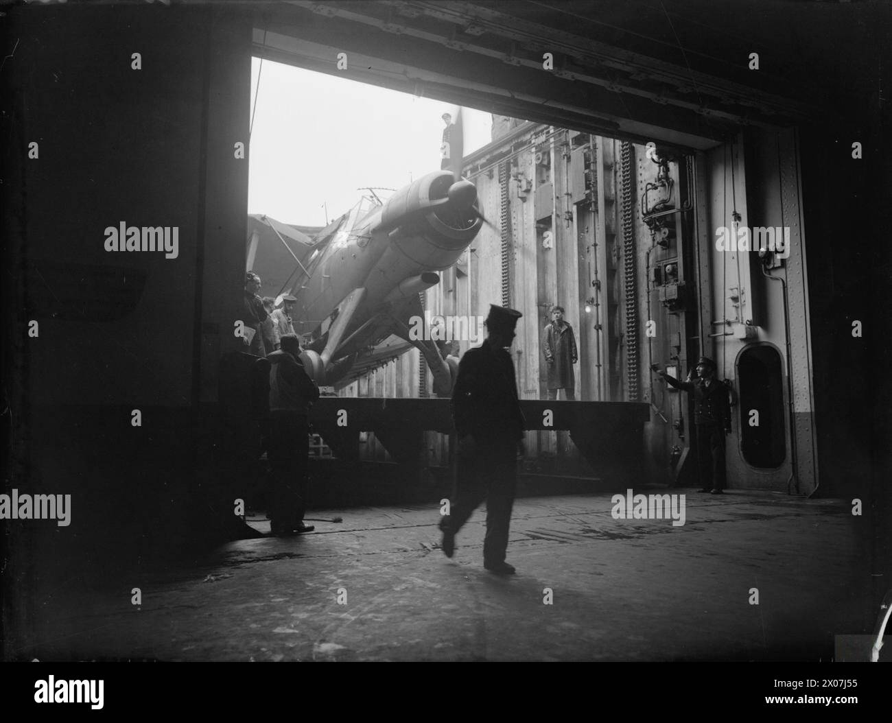 A Fairey Albacore is lifted to the flight deck aboard HMS Victorious in ...