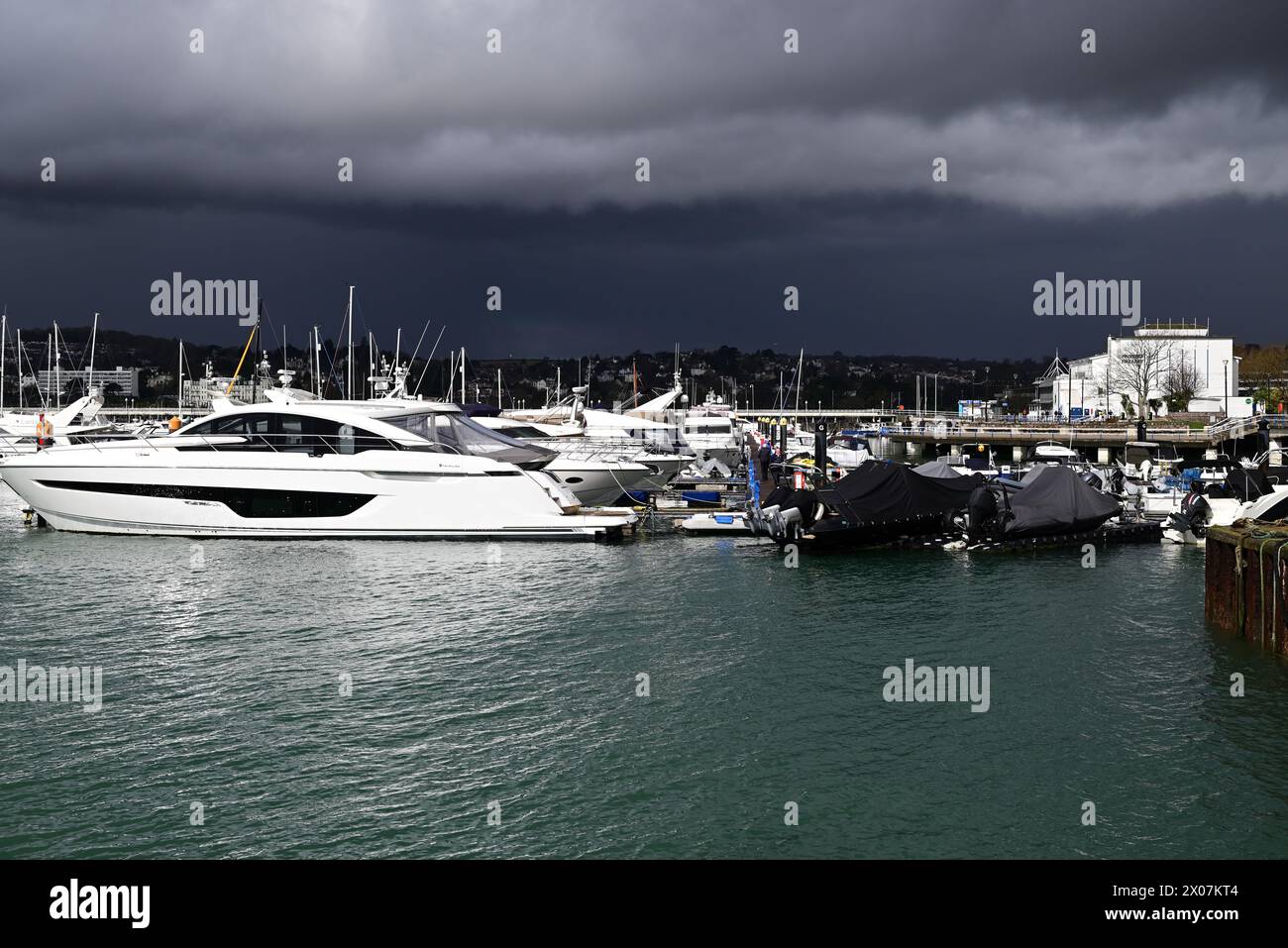 Sunshine and dark clouds over boats in Torquay harbour, as rain ...