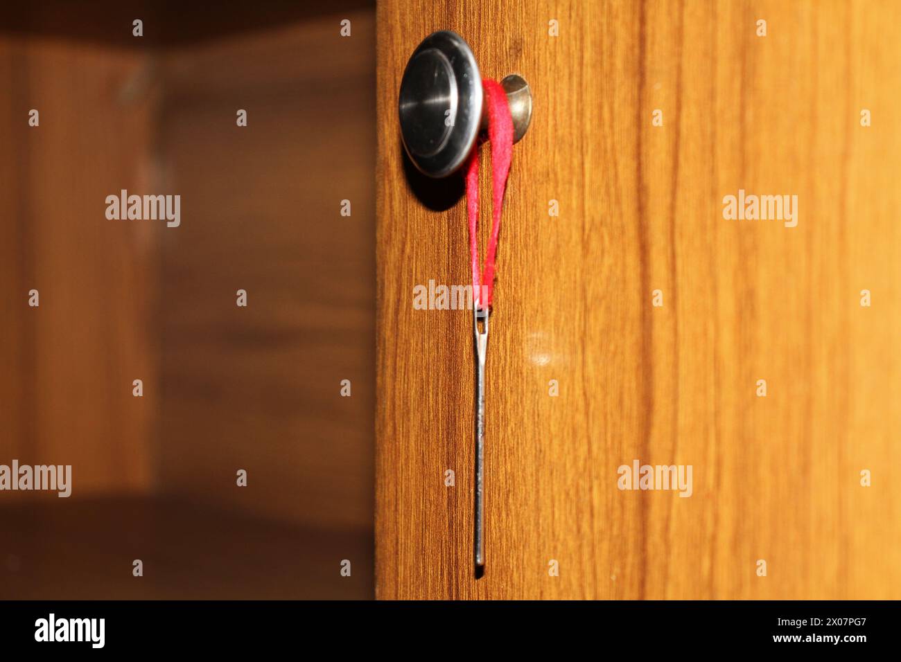 A sewing needle is hanging on a knob Stock Photo - Alamy